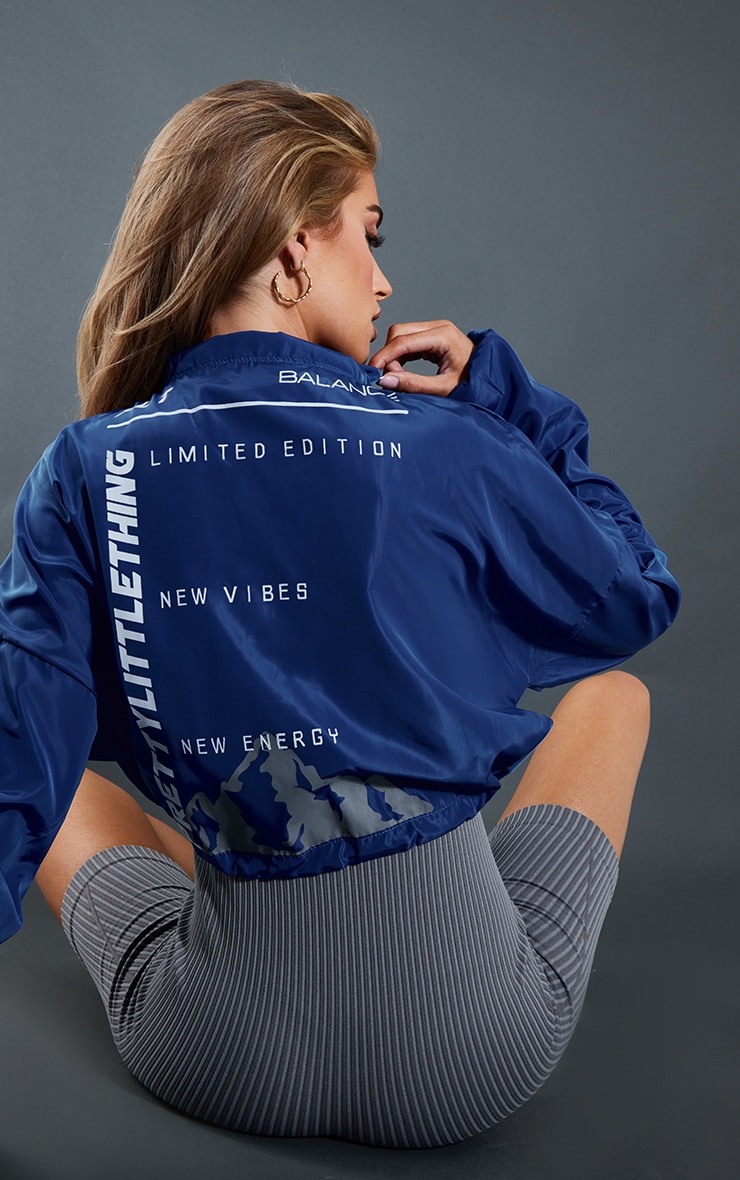 Plt Blue Graphic Drawstring Hem Crop Windbreaker | PrettyLittleThing KSA